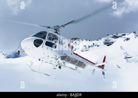 Rescue helicopter flying over snowy mountain Stock Photo - Alamy