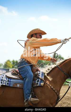 Man throwing lasso at rodeo event Stock Photo - Alamy