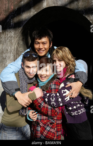 Four friends standing hugging each other in fresh air Stock Photo - Alamy