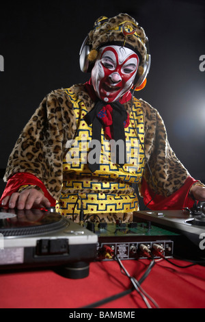 A DJ performing in a nightclub, using turntables and a mixer to control ...