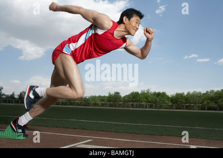 Powerful image of male athletes at the starting line of a 400m race on ...