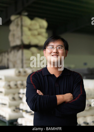 An employee of the New Wide Knitting and Dying factory standing among ...