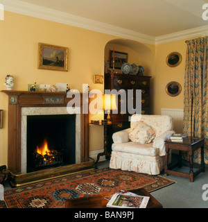 English country style living room with mantel piece, arm chair and rug ...