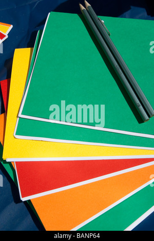 Brightly coloured school childrens exercise books and pencils on a ...