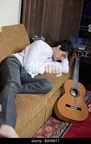 Asian man sleeping on sofa at home for illness recovery Stock Photo - Alamy