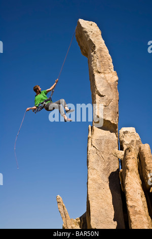 A rock climber rappelling from a rock spire Stock Photo - Alamy