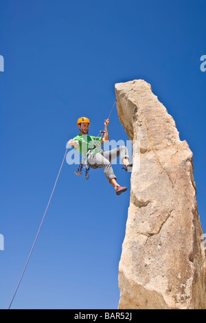 A rock climber rappelling from a rock spire Stock Photo - Alamy