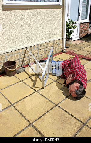 A man having lies injured on concrete steps having fallen over his ...