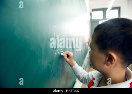 Young student practicing math on a chalkboard Stock Photo - Alamy