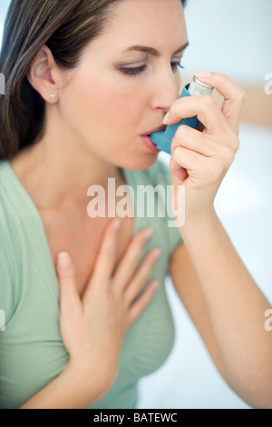 A person holds a Metered-Dose Inhaler above a cup containing a dark ...
