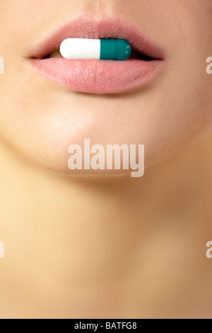 Pill between lips. Close up young woman with medicine pill in her ...