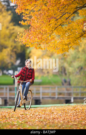 person riding bicycle in park on stone path way Stock Photo - Alamy
