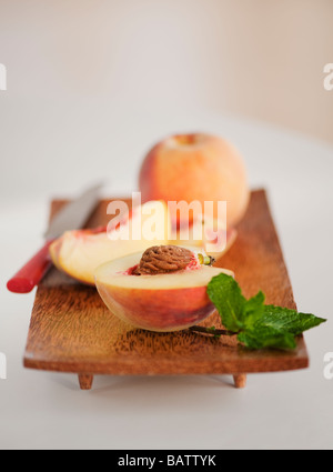 Peach fruit sliced with knife on white isolated background Stock Photo ...