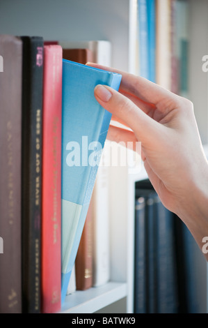 Woman selecting book from shelf, rear view Stock Photo - Alamy