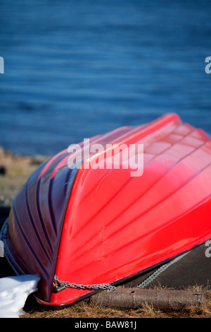 Upturned moored fiberglass red rowboat ( skiff / dinghy Stock Photo - Alamy