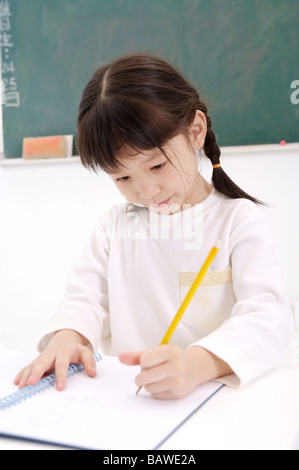 Vertical portrait of children taking notes while doing science ...