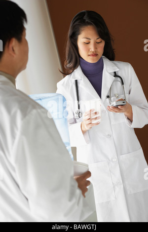 Asian female doctor using phone and tablet for medical consultation in ...