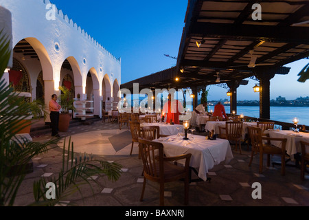 Waiters decorating tables on terrace of the restaurant Tamarind Mombasa ...