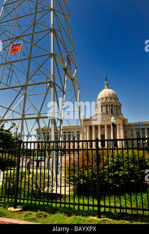 An oil derrick stands in front of the Oklahoma capitol building ...