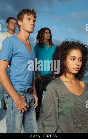 Four young friends standing together . The studio shot Stock Photo - Alamy