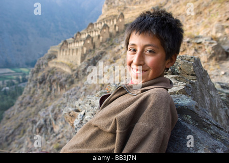 Boy in front of Aztec granary with town below, Ollantayambo, Peru Stock ...