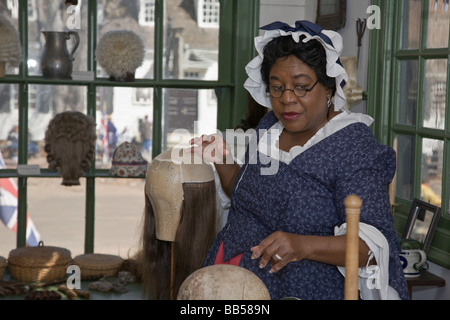 A woman portrays a colonial wigmaker in the Barber & Peruke Shop at ...