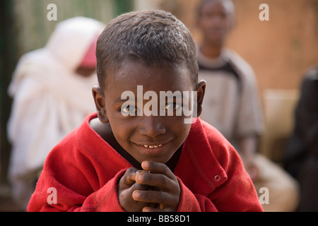 A young Fulani boy in Ouagadougou, Burkina Faso wraps a turban around ...