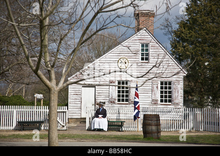 A woman sits outside the gunsmith in Colonial Williamsburg, Virginia ...