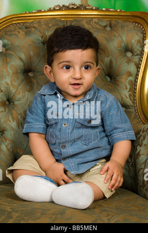 Arab boy sitting on sofa with a football Stock Photo - Alamy