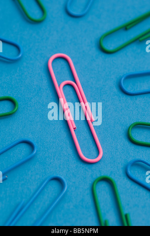 Close up of pink paper clips in circle and copy space on blue ...