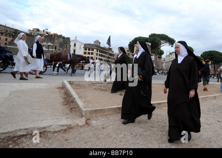 A Roman Catholic nun walking along a busy street amongst other people ...