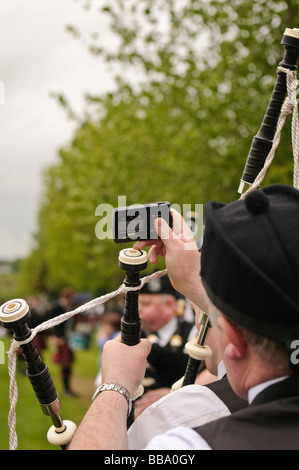 Using a digital tuning guide to tune the drones on a bagpipe at the ...