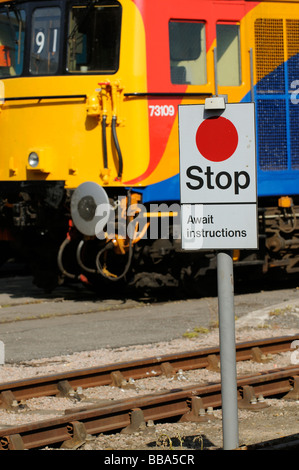 Stop await instructions sign alongside railway track Stock Photo - Alamy