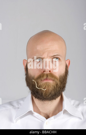 A man with messy hair and a shaved head is screaming. He has his hands ...