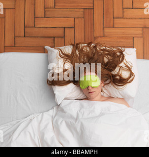 Young caucasian woman wearing sleep mask and pajamas over isolated pink ...