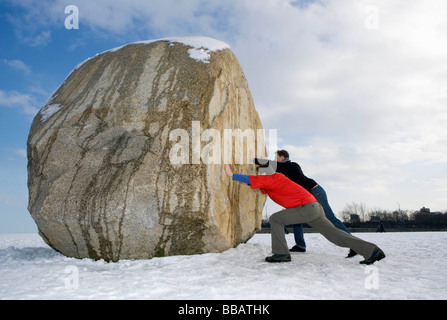 2 men pushing boulder Stock Photo - Alamy