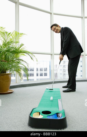 business executives playing golf in an office Stock Photo: 26241664 - Alamy