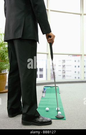 business executives playing golf in an office Stock Photo: 26241664 - Alamy