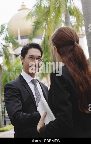 Businessman and businesswoman shaking hands in office corridor Stock ...