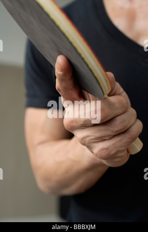 Hand Holding A Paddle Tennis Racket Hitting The Ball On An Orange ...