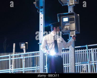 Security Guard At Entrance Gate At Night Stock Photo - Alamy