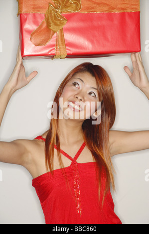 Woman arms holding gift box with pink ribbon on color background, top ...