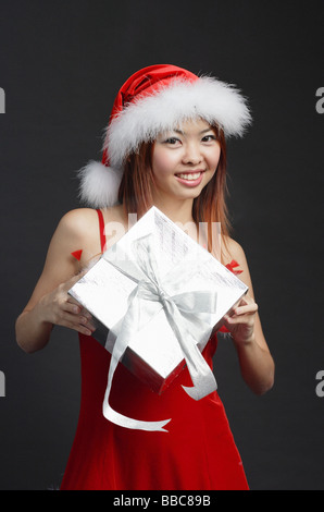 Woman with Santa hat holding red bag on blue background Stock Photo - Alamy