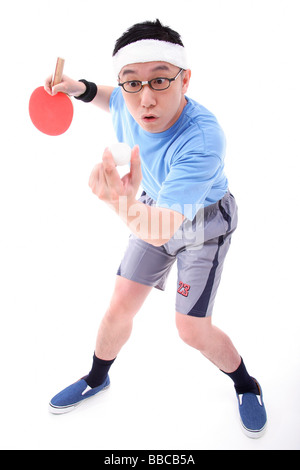 Man with ping pong racket preparing to hit a ball, workout indoors ...