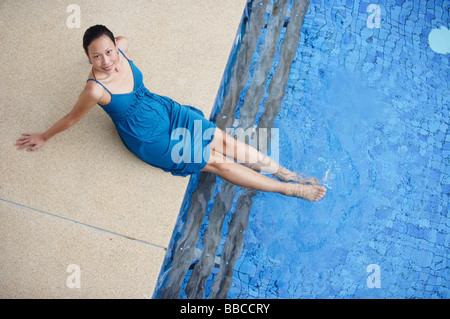 A young woman dipping her feet into a swimming pool Stock Photo - Alamy