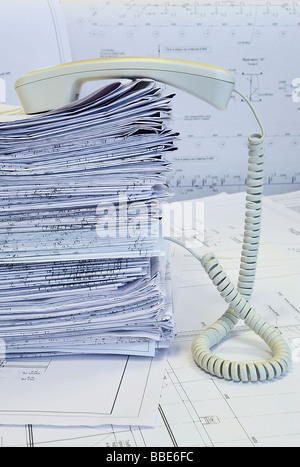 Big heap of design and project drawings in yellow folder on the table ...