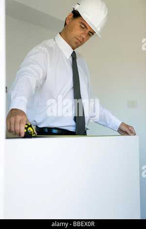 A man is holding up a ledge for construction workers doing maintenance ...