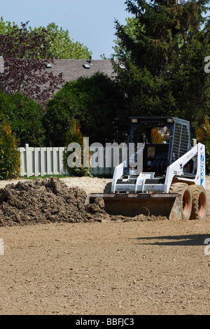 Landscaping on a garden with a small bulldozer nobody none horizontal ...
