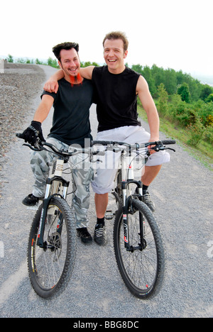 A mountain biker riding past two walkers on a trail in Cardinham Woods ...