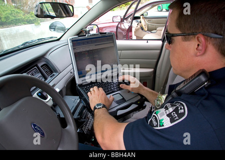 Police officer using a mobile data terminal computer inside a police ...